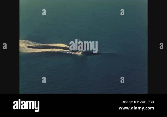 1964 - An aerial view shows a submarine breaching. An underwater view ...