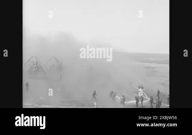 Firefighters spray the smoldering flight deck of the USS Intrepid and ...