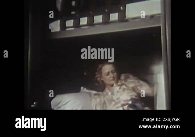 1940 - A train conductor and passenger use telephones aboard the train ...