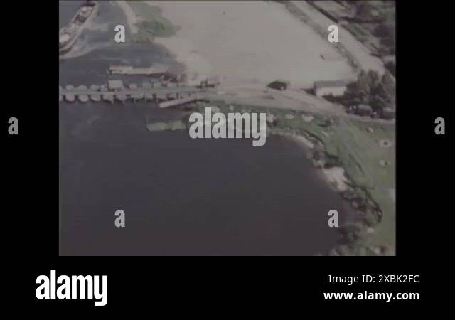1945 - Destroyed buildings and collapsed bridges in a river are shown ...