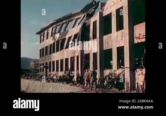 1945 - Soldiers use a tape measure as they examine ruined buildings in ...