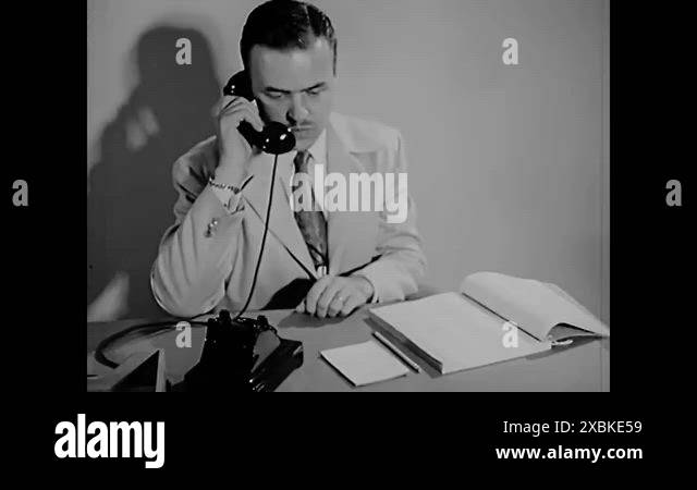 1951 - Components of a rotary phone are shown in close-up as a man ...