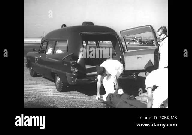 Stretcher bearers load a patent into a ambulance at Andres Air Force ...