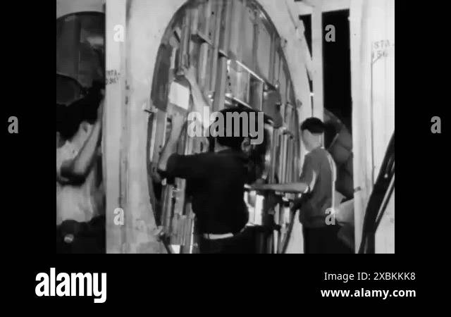 A revolving jig is used by drillers and riveters on an assembly line as ...