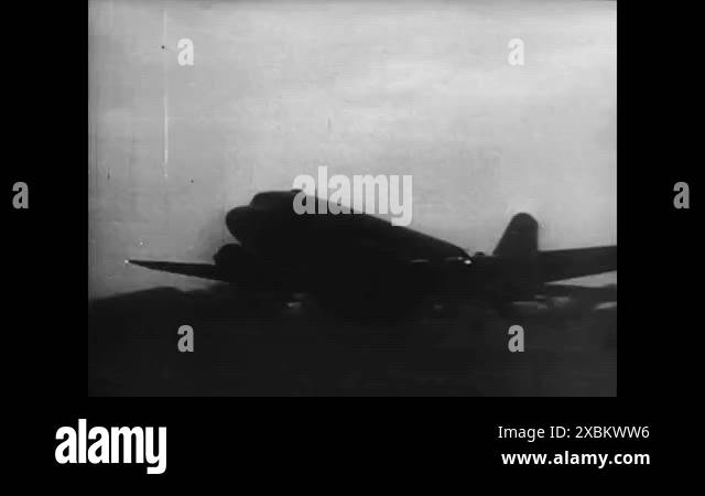 United States Army paratroopers smoke and jump out of a warplane on D ...