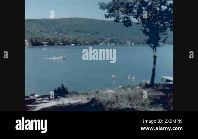 1965 - People swim in Culver Lake, play in a fountain, look at Memorial Tower, and swim and ...