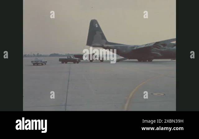 1967— Military vehicles are driven onto aircraft, and a plane taxis at ...