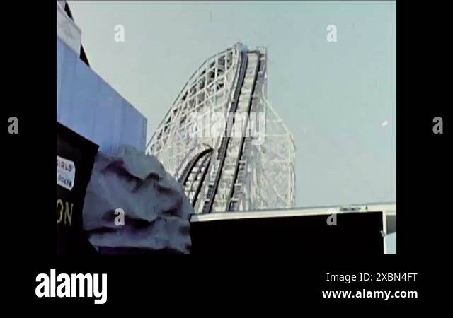 1967 - An amusement park is shown and a rider on a carnival ride holds ...
