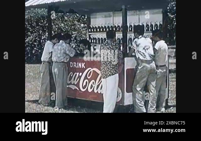 A woman drinks a Coca Cola by the swimming pool in the 1950s Stock ...