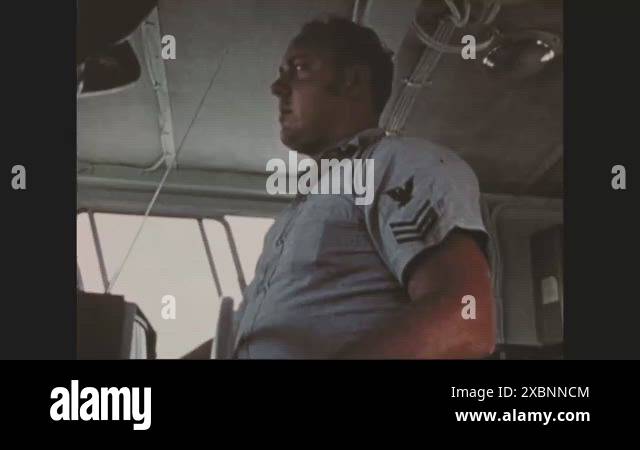 1972 - A torpedo recovery boat is followed by a pilot whale being fed fish by trainers in ...