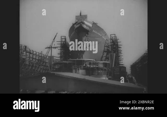 1944 - Henry Kaiser watches as a champagne bottle is broken on the hull ...