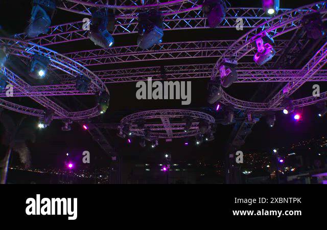 Tilt down from rooftop to hundreds of people partying at a giant open ...