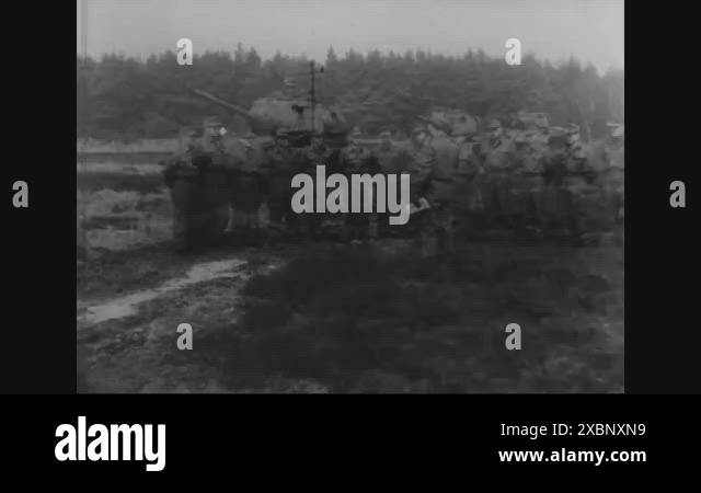 1947 - Officers refer to a map and soldiers board a tank in West ...
