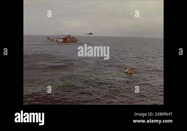 Divers recover the unmanned Apollo command module after a splashdown ...