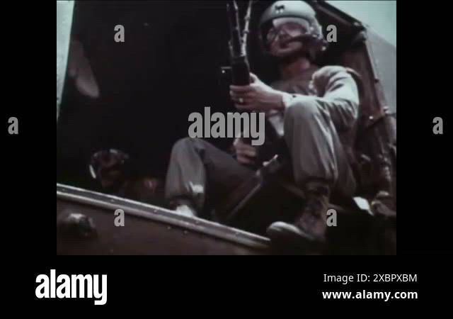 A US Military helicopter door gunner flies in a Huey during his first ...