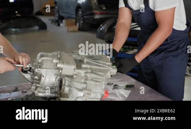 Two mechanics repair an electric car engine in a service garage ...
