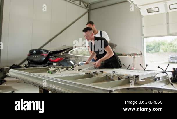 Two Mechanics Troubleshooting An EV Car Battery Module In A Workshop ...