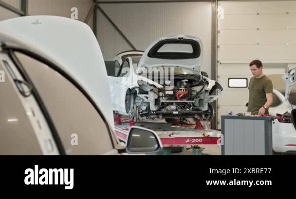 Mechanic working on car repair and body alignment in a clean, modern ...