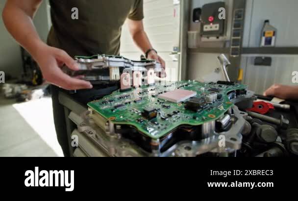Mechanic handling and repairing an electric car engine inside a modern ...