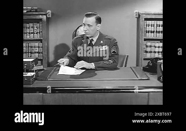 A United States Army sergeant sits at his desk and speaks in 1954 Stock ...
