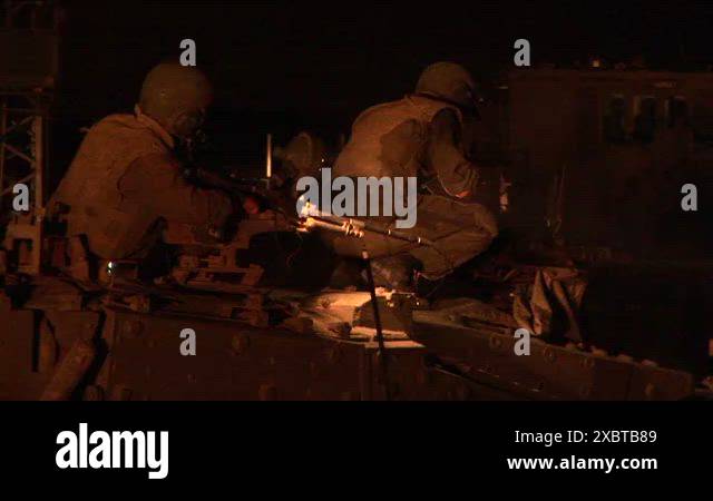 An Israeli soldier works on a machine gun during a wartime operation ...