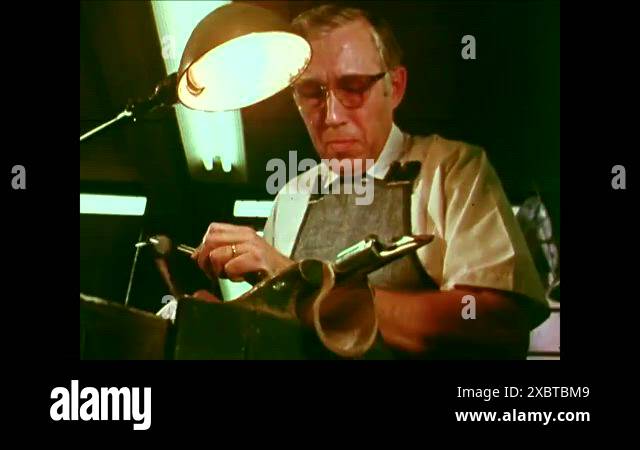 A rifle is hand engraved at a Dupont gun facility in the 1960s Stock ...