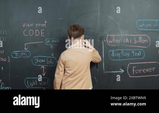 Back view of smart boy writing engineering prompt on blackboard ...