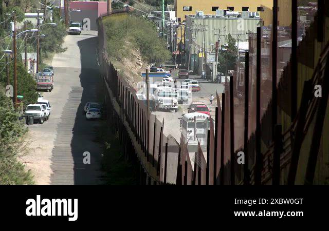 A border fence shows the separation of a community between a rural area ...
