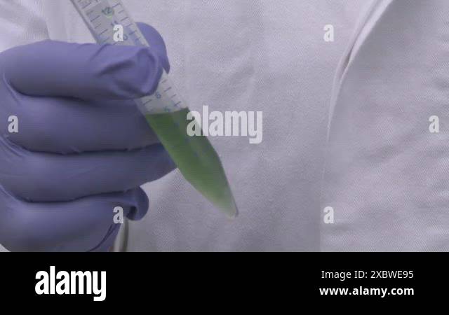 Mysterious green liquid contained in a test tube is held by a scientist ...