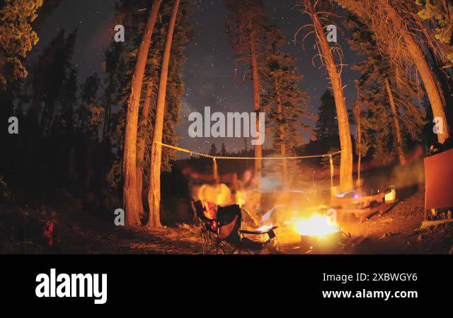 Motion night time lapse of the milky way and stars above a campfire at ...