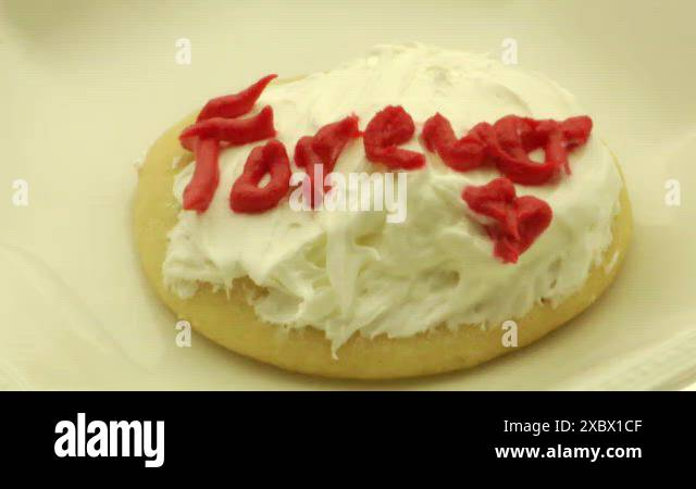 A woman's hand picks up a cookie with the words Forever spelled out in ...