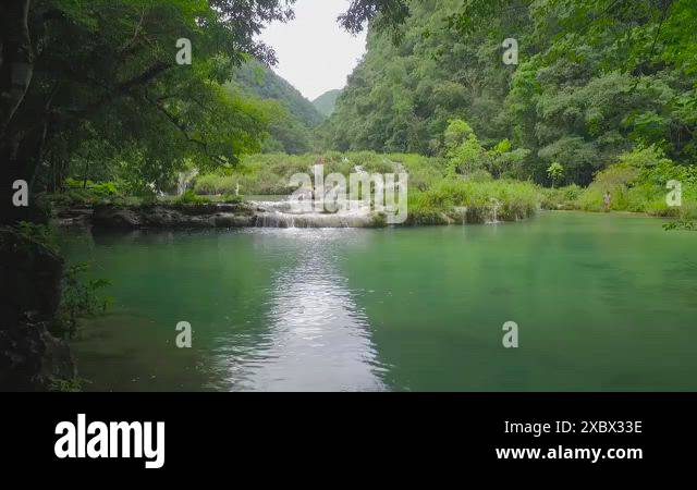 An aerial over remarkable waterfalls and green polls on the Semuc ...