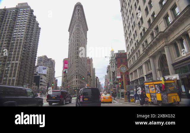 Traffic passing in front of New York's iconic Flatiron Building Stock ...