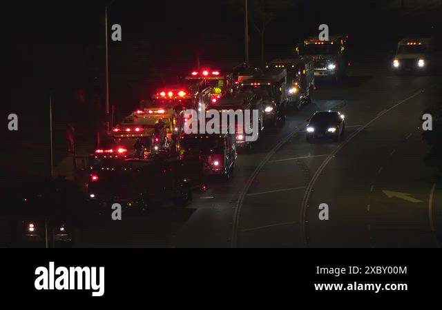 Fire trucks and emergency vehicles are lined up in a staging area at ...