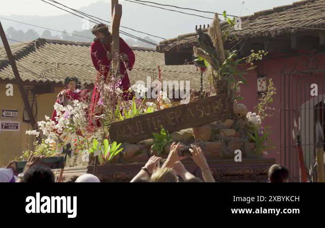 Women carry giant statues of Jesus and the cross in a colorful ...