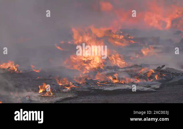 2019 - pallets and boxes burn on the ground while firefighters battle ...