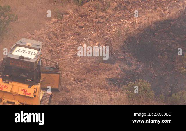 2021 - Bulldozer cuts a fire line along a hillside during the Alisal ...