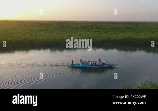 2020 - beautiful aerial over small boat moving along the Gambia river ...
