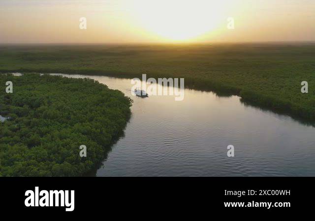 2020 - beautiful aerial over small boat moving along the Gambia river ...