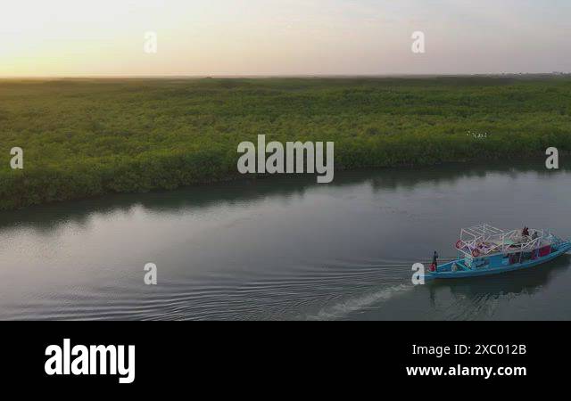 2020 - beautiful aerial over small boat moving along the Gambia river ...