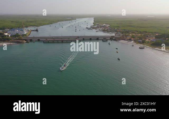 2020 - beautiful aerial over long boat moving along the Gambia river in ...