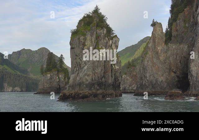 ALASKA - 2023 - View from a kayak as it sails past giant green-topped ...