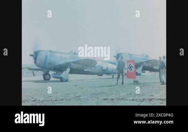 1945 - A US Army Air Force crew chief uses a Nazi flag to wave down P ...