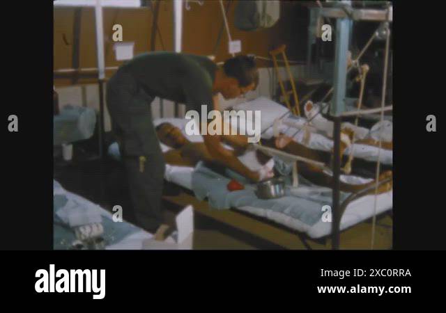 1969 - A US Army medic dresses a Vietnamese POW's leg wound in a field ...