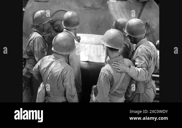 1943 - An army platoon prepares for combat by studying the terrain and ...