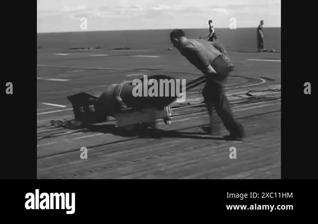 1950 - US Navy crewmen load bombs and ammo belts onto F4U planes aboard ...