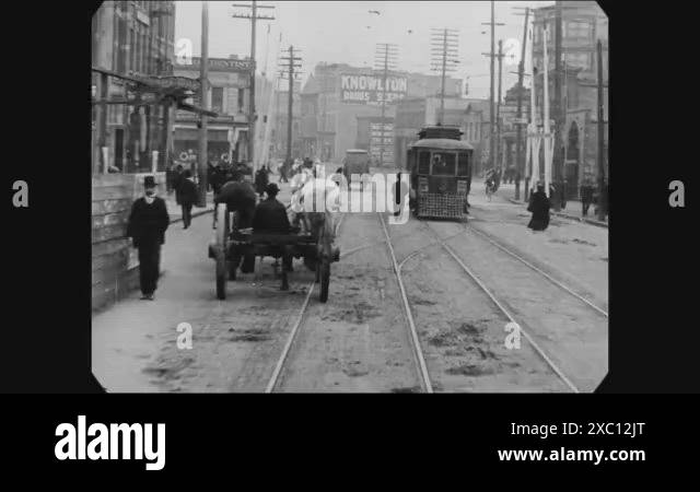 1907 - Pedestrian and vehicular traffic is seen on a city street in ...