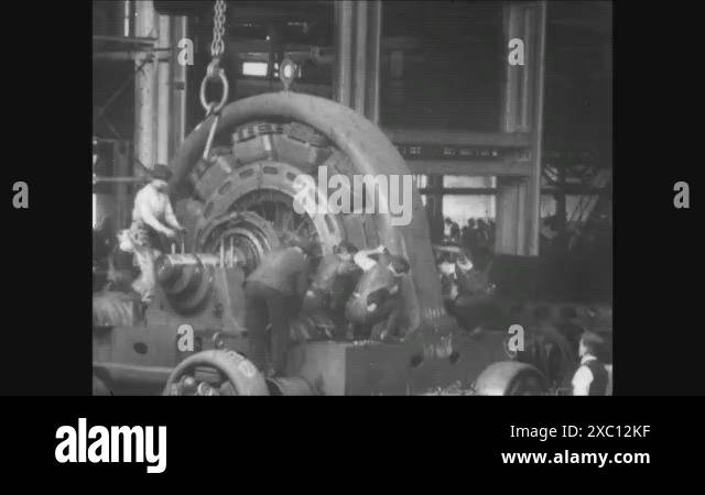 1920s - Factory workers complete assembling a large electric generator ...