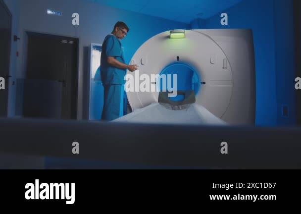 Medium slowmo tilt of male medical imaging specialist wearing blue ...