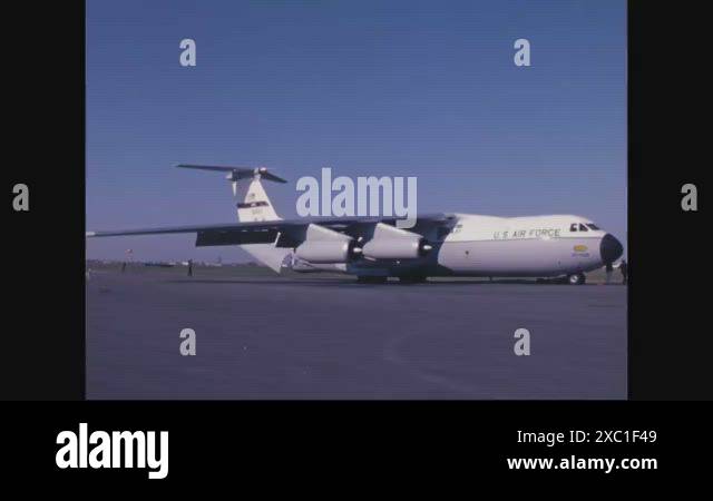 1973 - A USAF airman walks his unit's dog mascot alongside a C-5A Stock ...